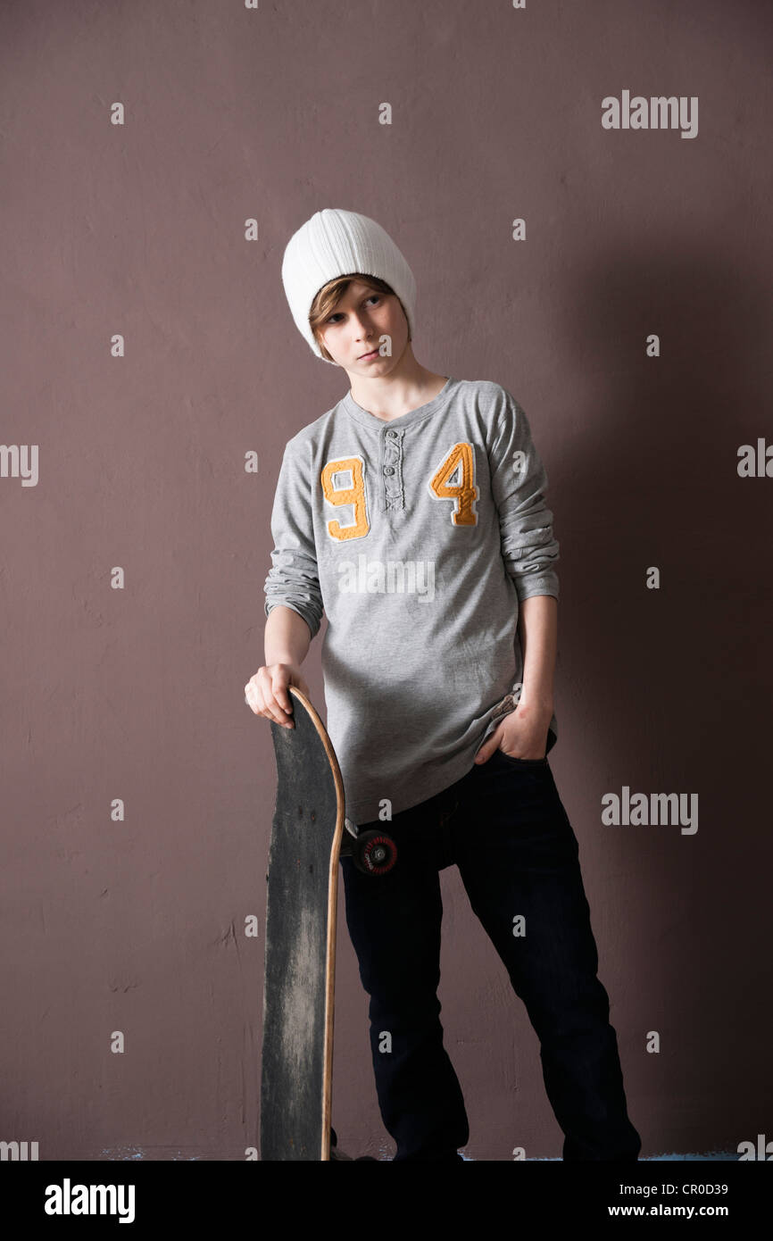 Cool boy wearing a cap and holding a skateboard Stock Photo - Alamy