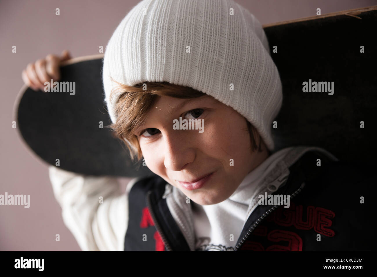 Cool boy wearing a cap and holding a skateboard Stock Photo - Alamy