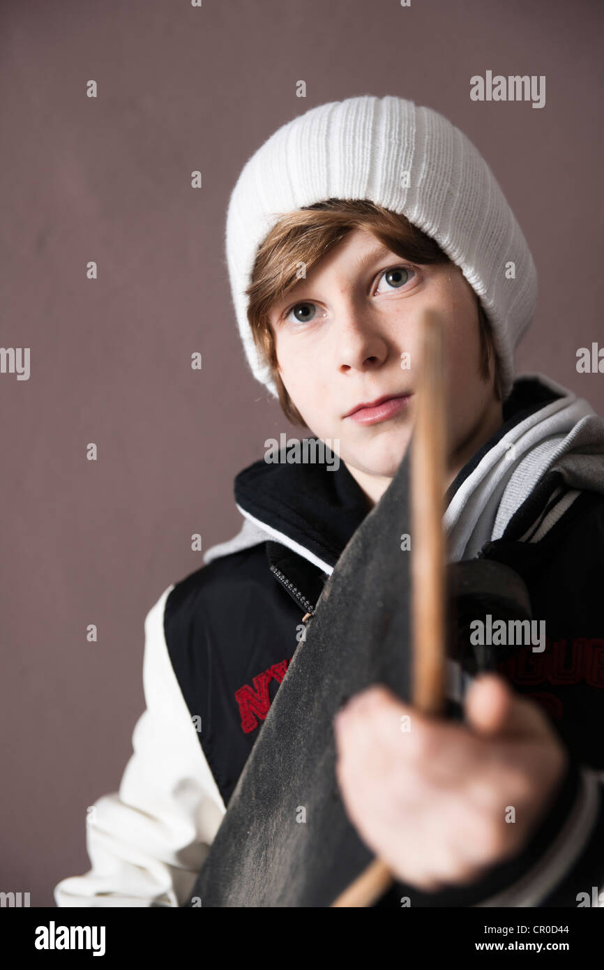 Cool boy wearing a cap and holding a skateboard Stock Photo - Alamy