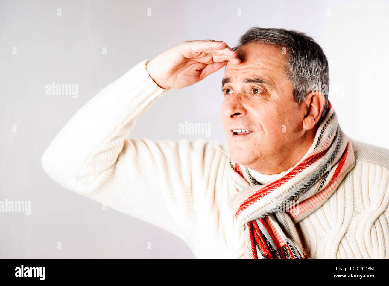 Elderly man wearing a scarf, looking searchingly into the distance ...