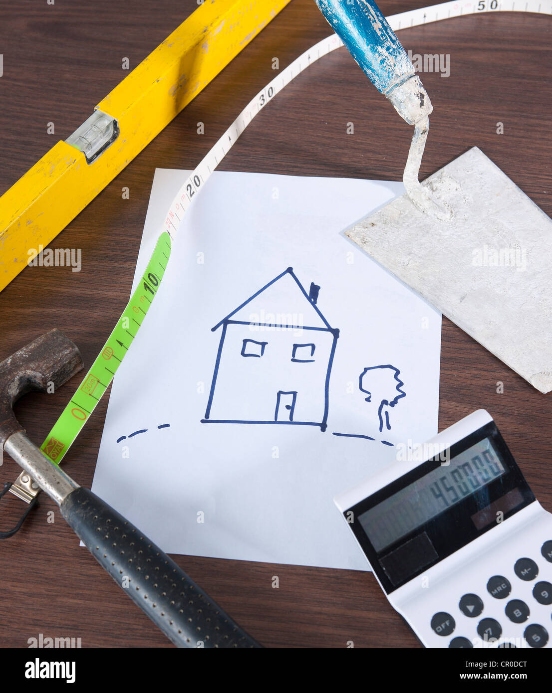 Calculator, spirit level, tape measure and a trowel on a drawing of a ...