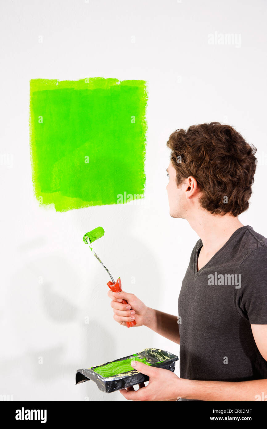 Young man painting a wall Stock Photo - Alamy
