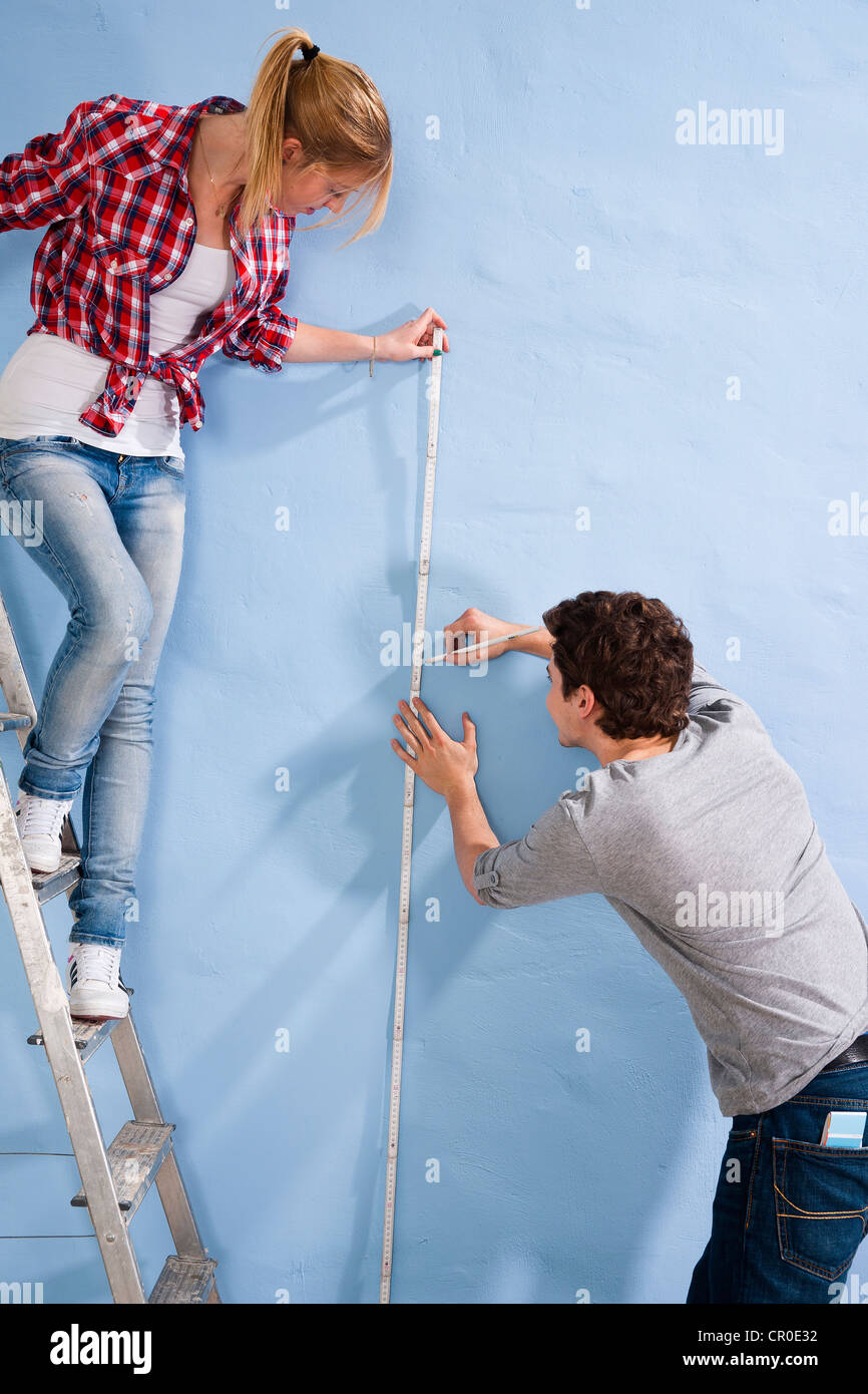 Young couple measuring a wall Stock Photo - Alamy