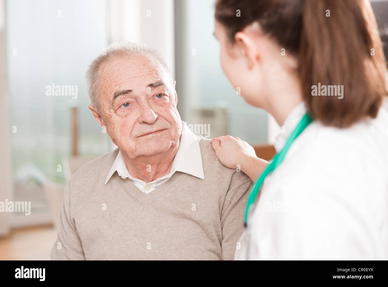 Young doctor taking care of an elderly man Stock Photo - Alamy