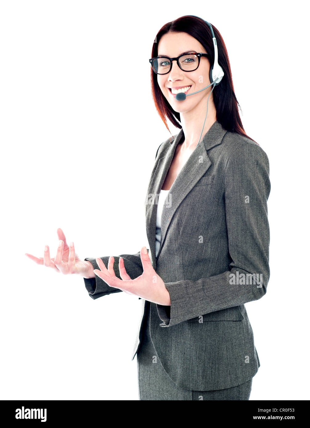 Smiling telemarketing girl posing in headsets against white background ...