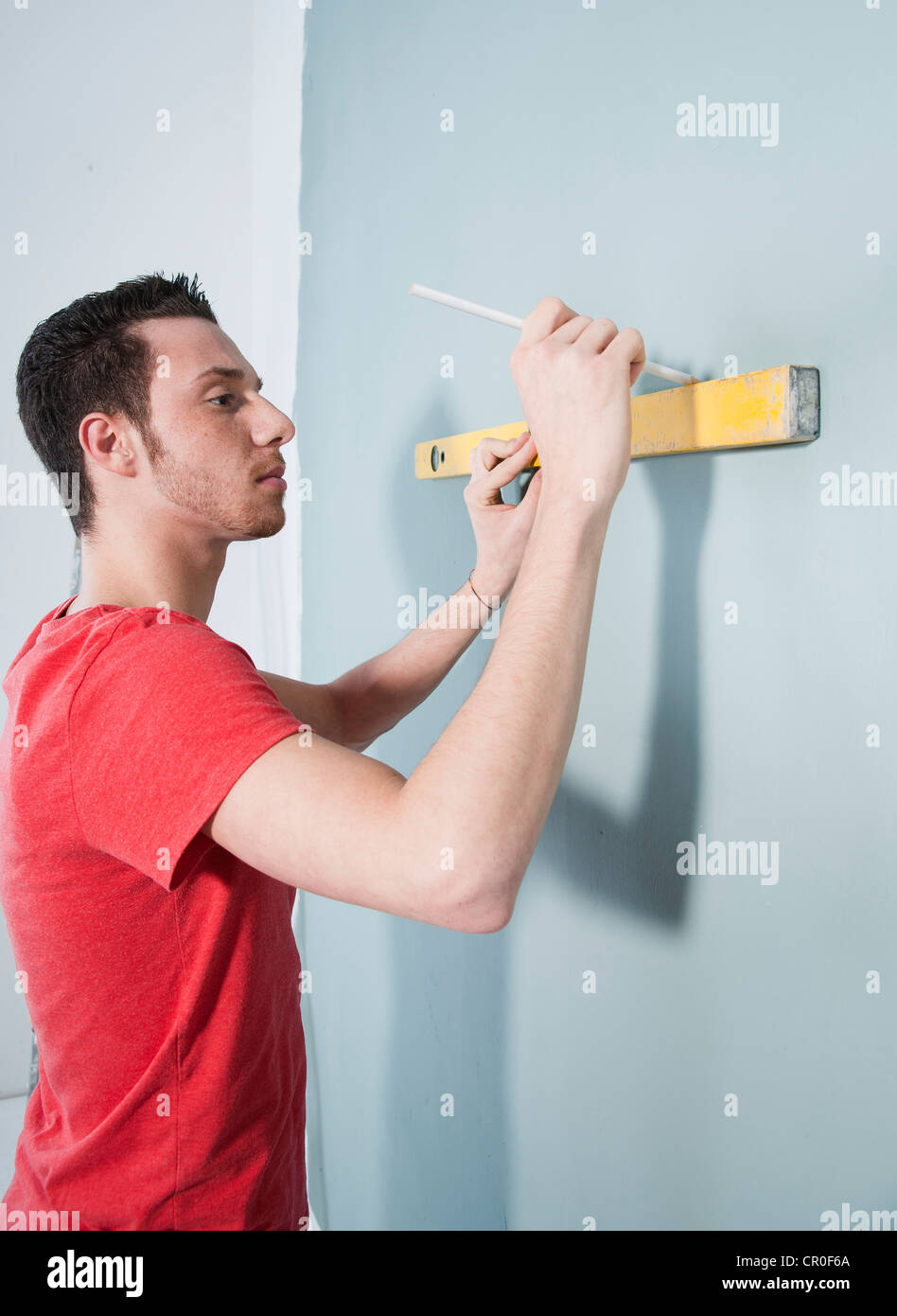 Young man using a spirit level Stock Photo - Alamy