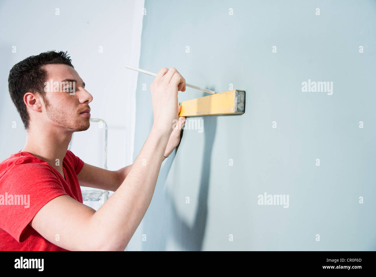Young man using a spirit level Stock Photo - Alamy