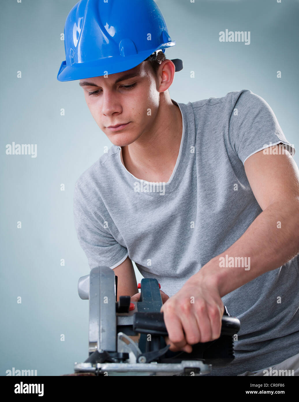 Young tradesman using a jigsaw Stock Photo - Alamy