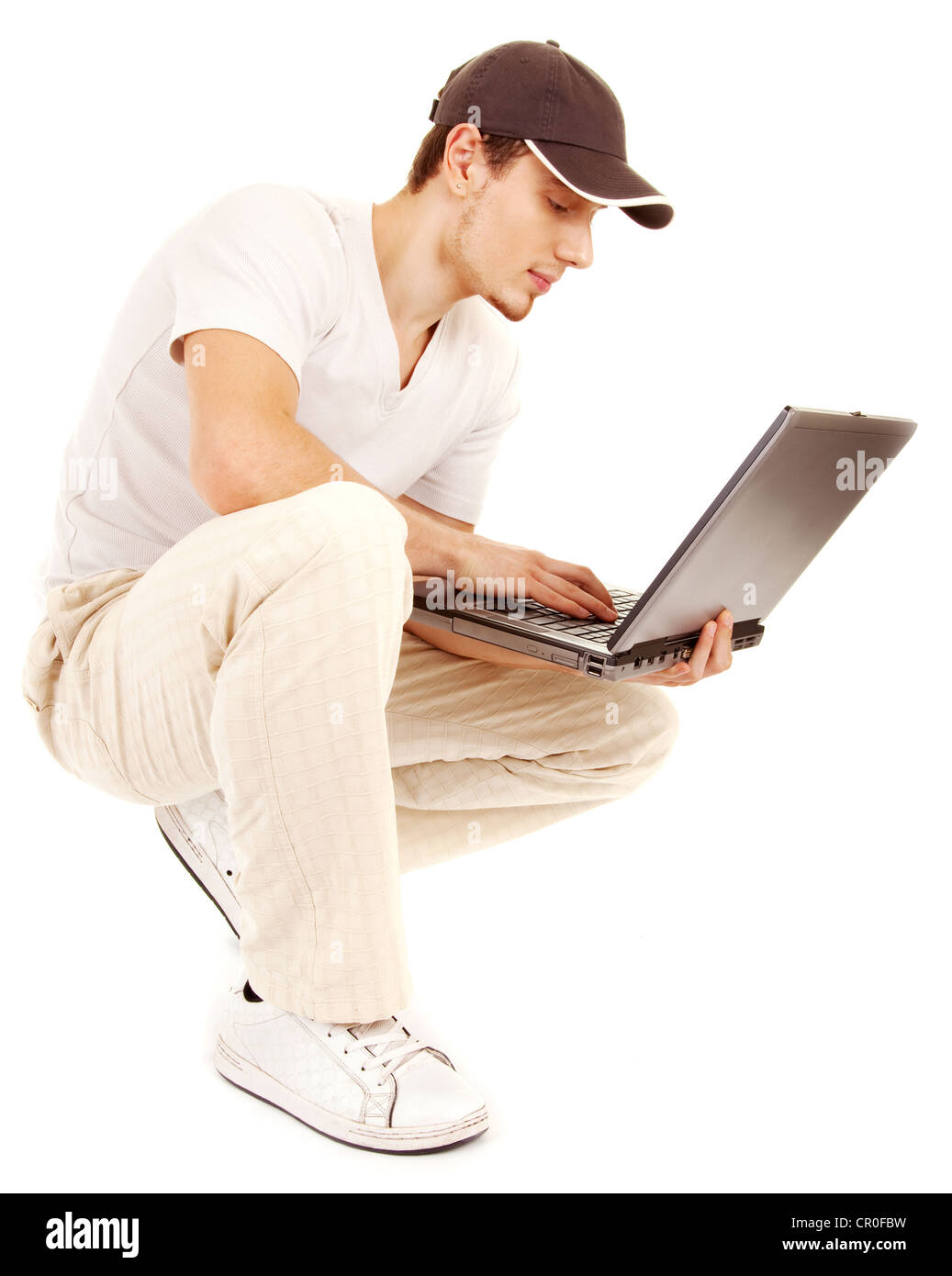 Handsome casual sitting man with open laptop and is looking on a screen ...