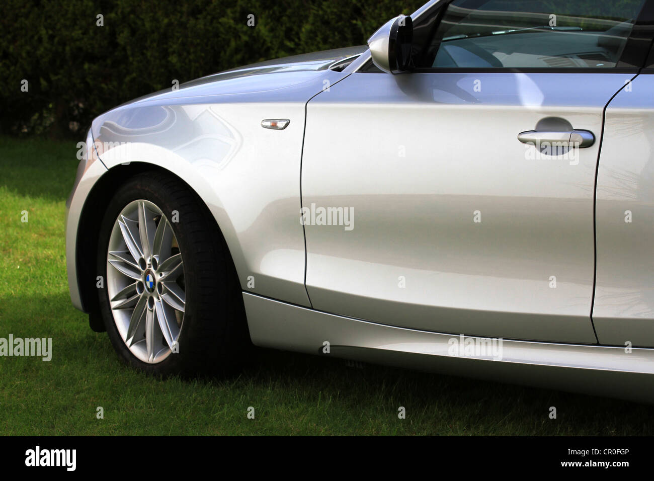 Baby BMW, silver from the side green background and hedge. The BMW 1 ...
