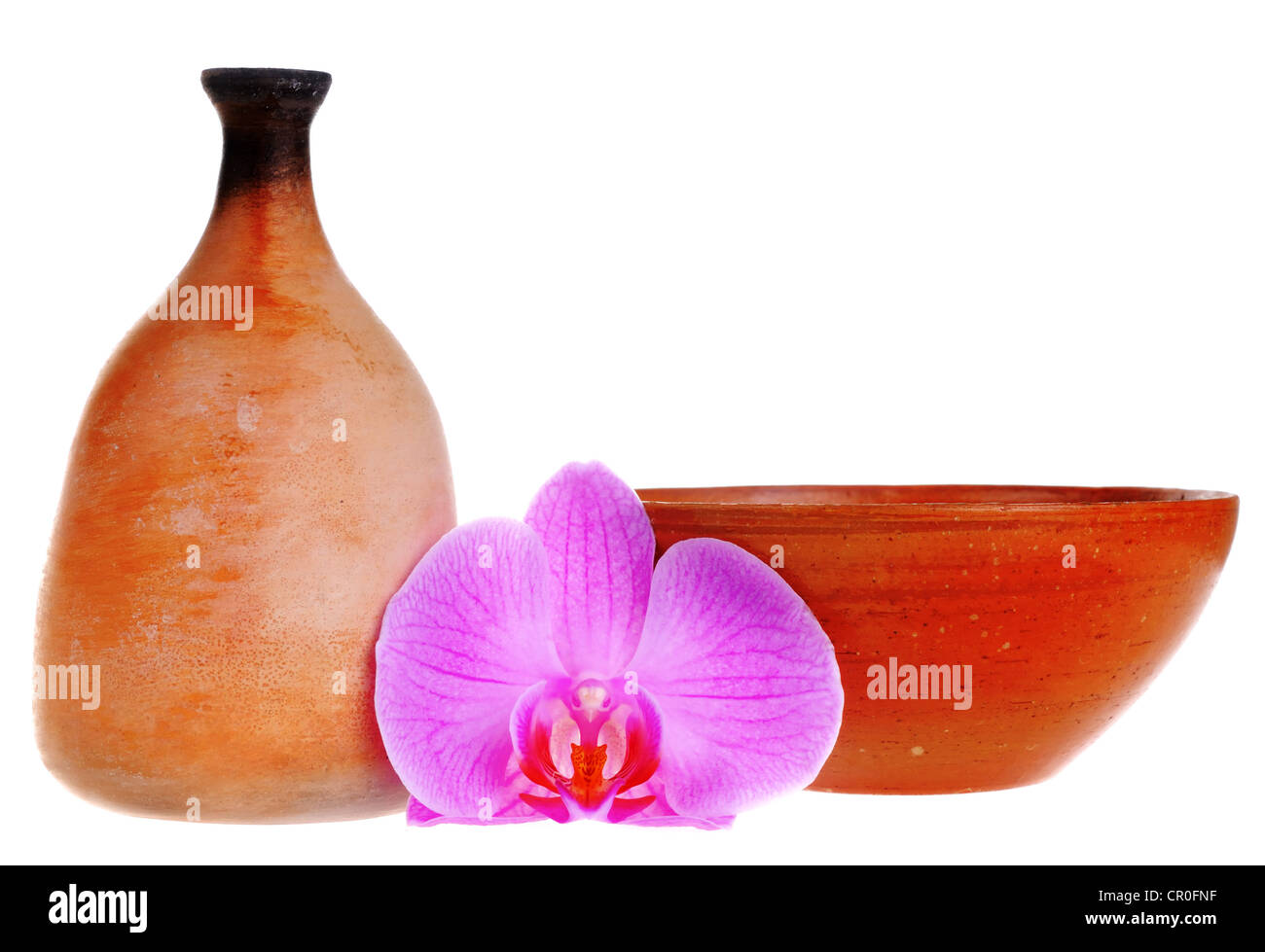 Old-fashioned clay jag and dish with orchid flower isolated on white ...