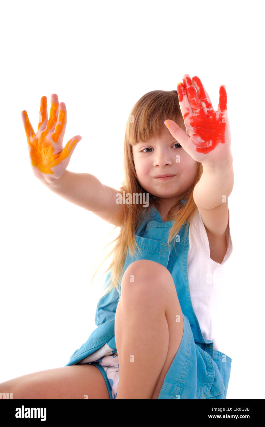 Small playful beauty girl with many-coloured hands on white background ...