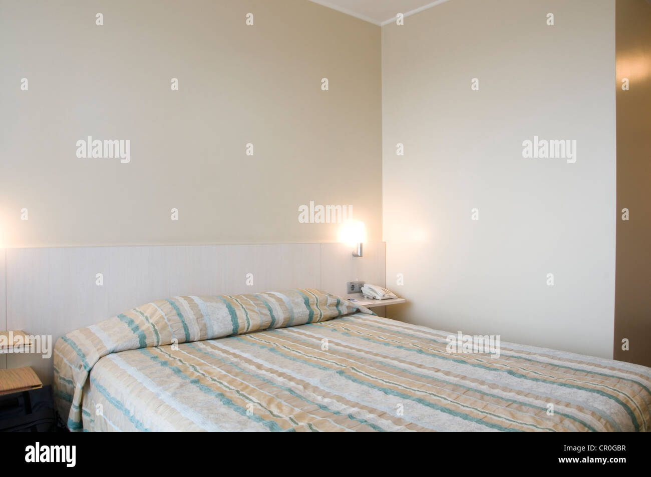 Hotel economy room with bed, telephone and empty walls Stock Photo - Alamy