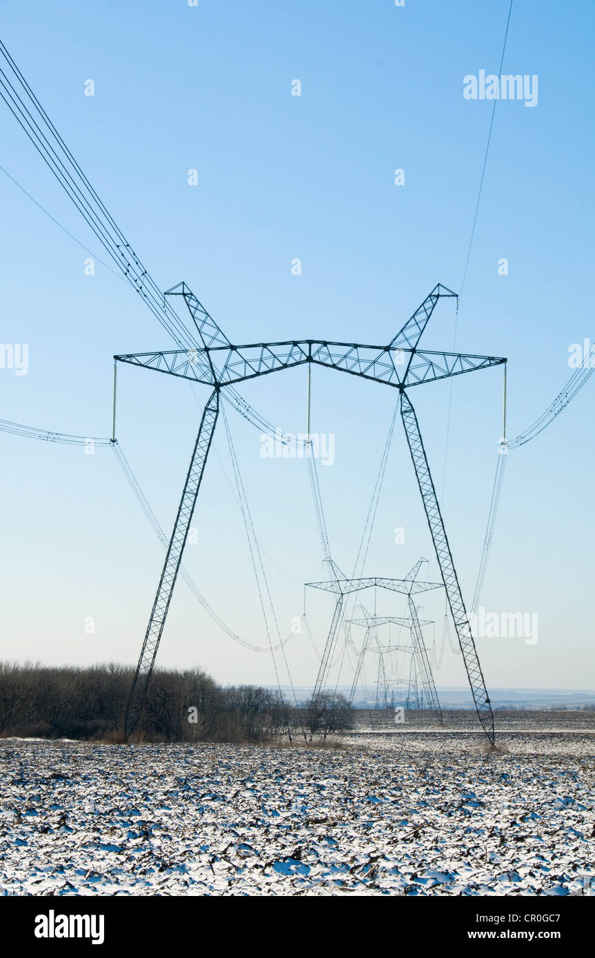 Line of electric pylons on winter snow-covered field Stock Photo - Alamy