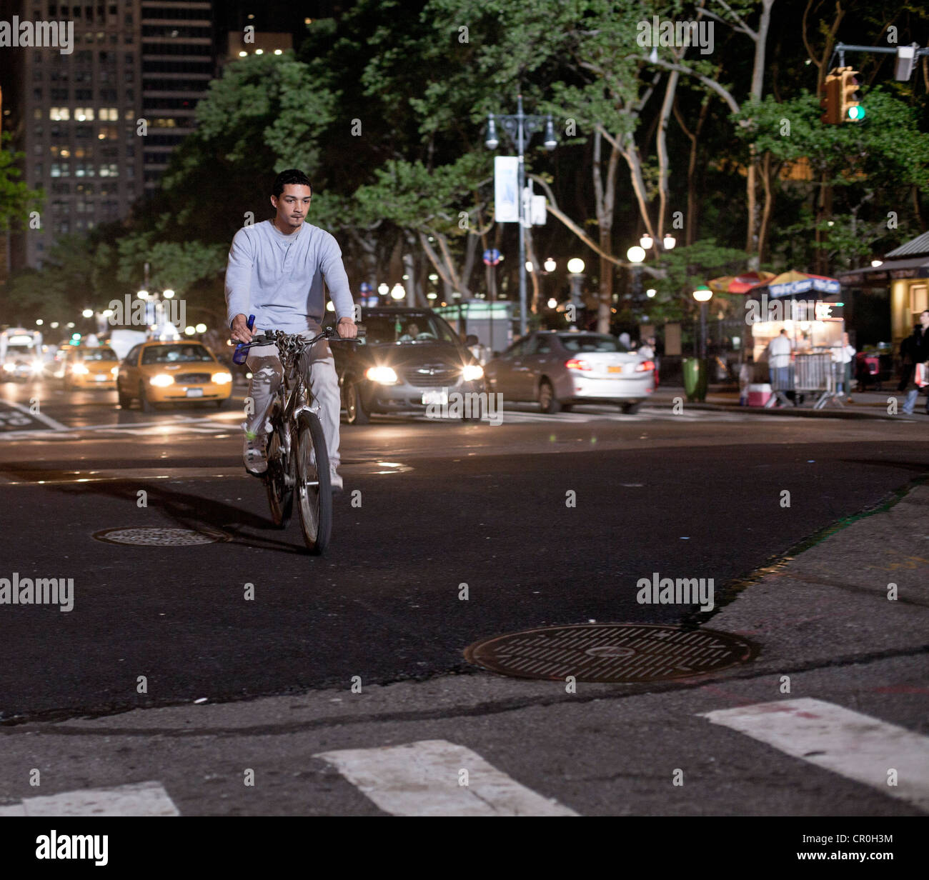 A man rides his bike without a helmet at night in New York City Stock ...