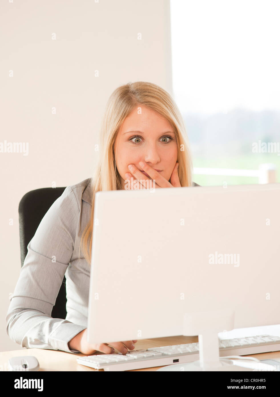 Young woman working on computer, puzzled Stock Photo - Alamy