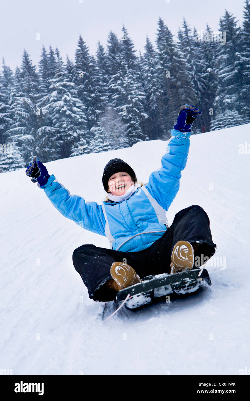 Girl sledding in the snow Stock Photo - Alamy