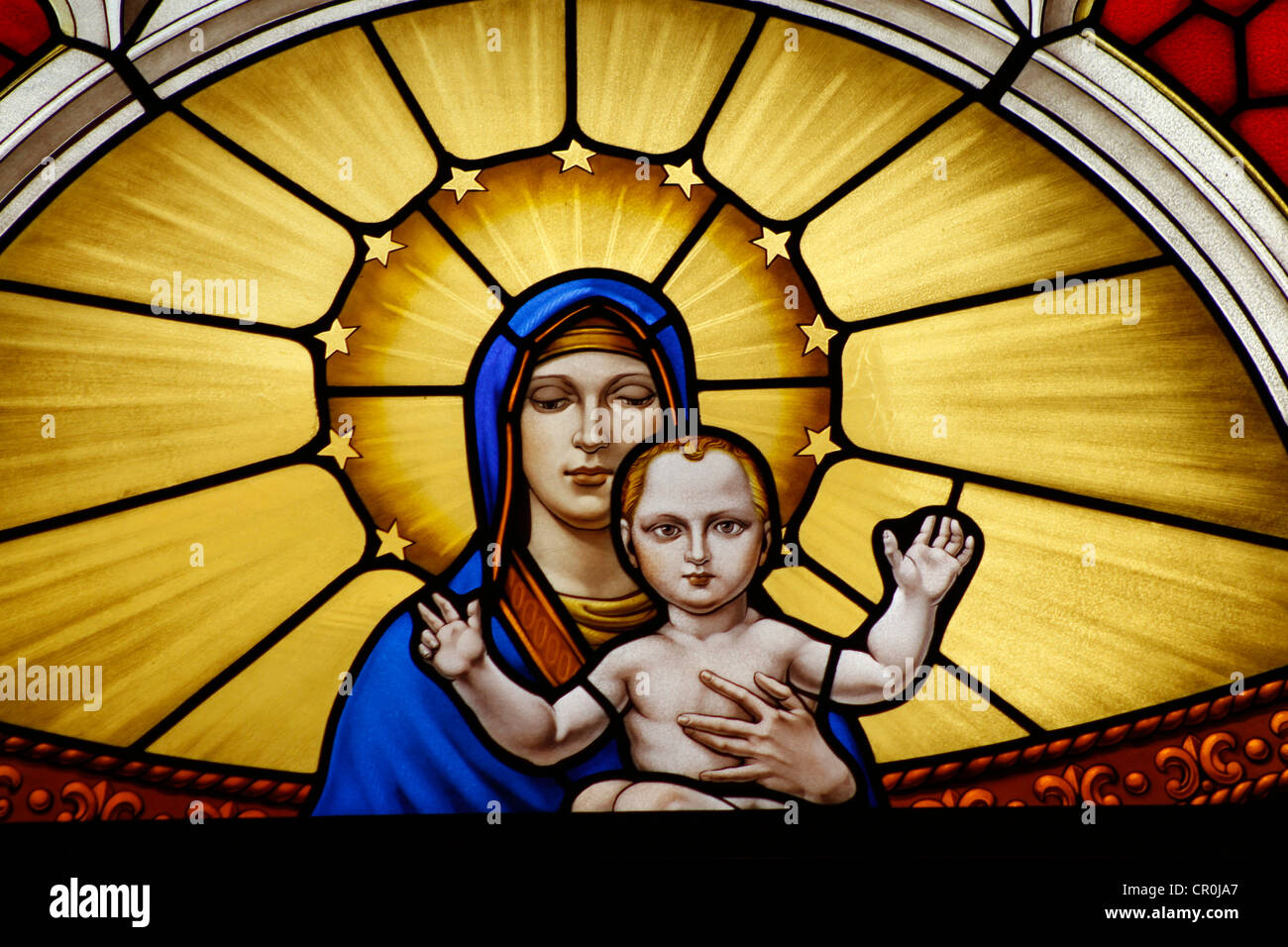 An stained glass window with the Virgin Mary holding Baby Jesus in the ...