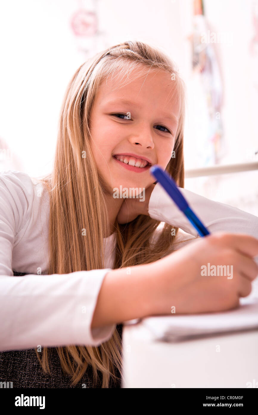 Girl, 9, seated at her desk Stock Photo - Alamy