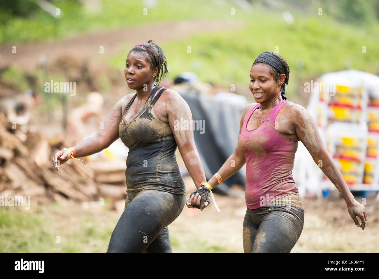 Happy female couple holding hands after finishing challenging sprint ...