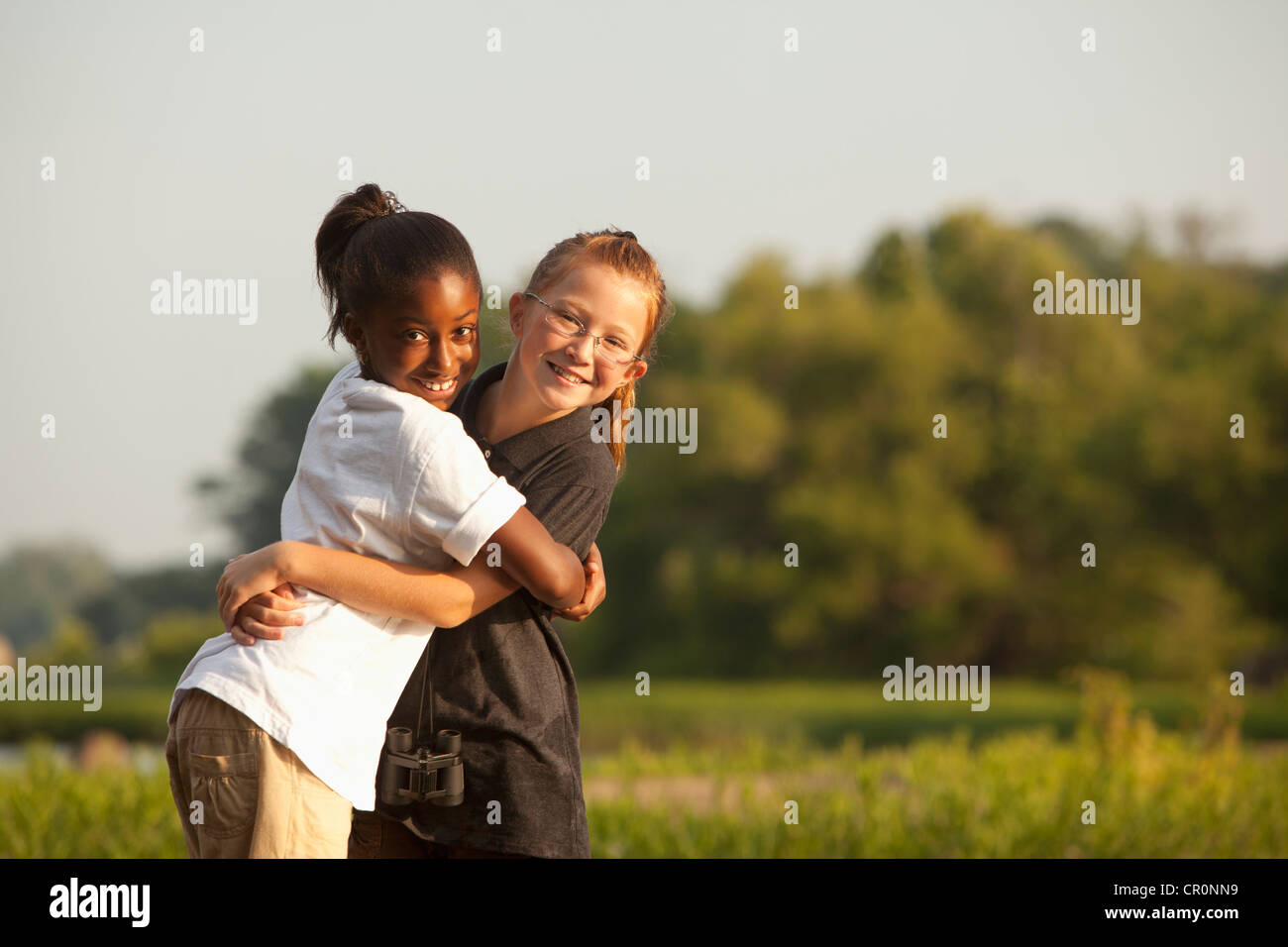 Girls hugging each other outdoors Stock Photo - Alamy