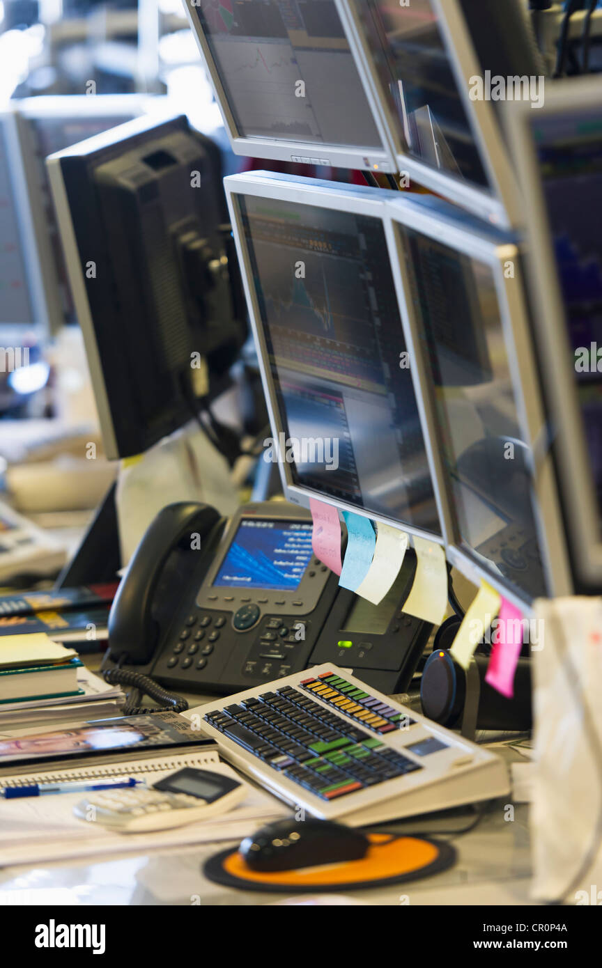USA, New York, New York City, Trading desk with computers and phones ...