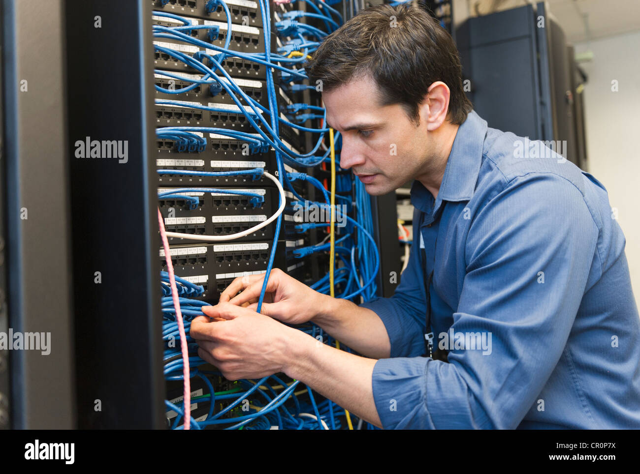 USA, New York, New York City, Technician inspecting network server ...