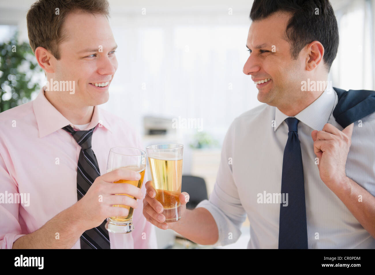 Businessmen toasting with beer Stock Photo - Alamy