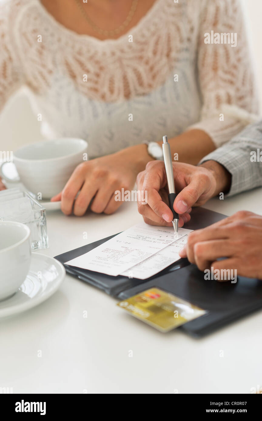 USA, New Jersey, Jersey City, Couple enjoying tea, man signing receipt ...