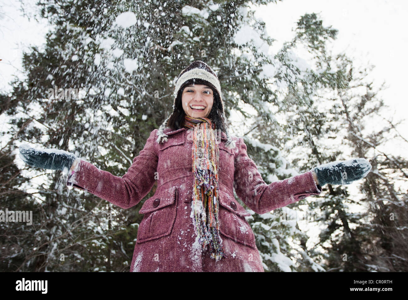 Caucasian woman throwing snow Stock Photo - Alamy