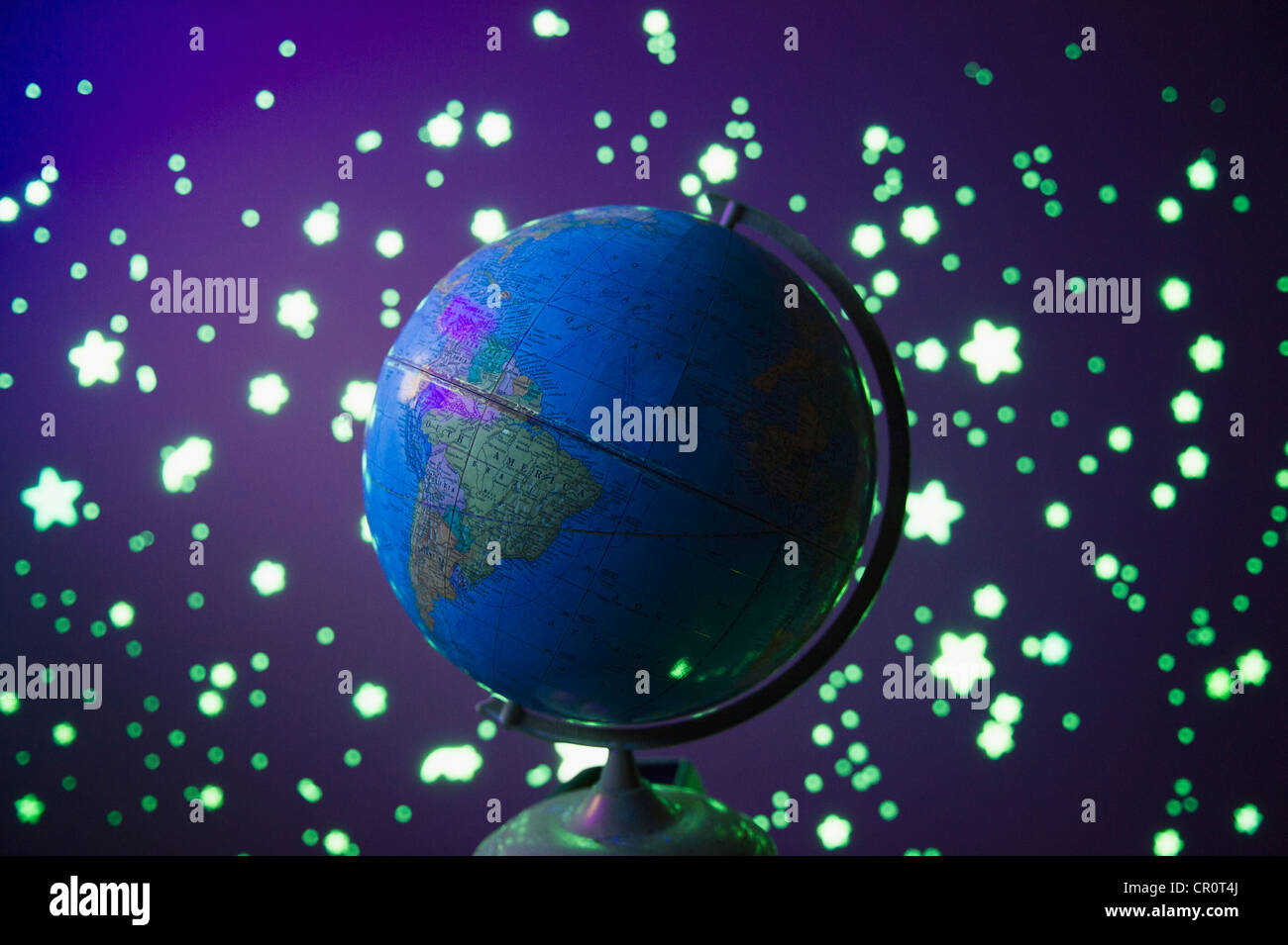 Fluorescent stars and globe on blue background, studio shot Stock Photo ...