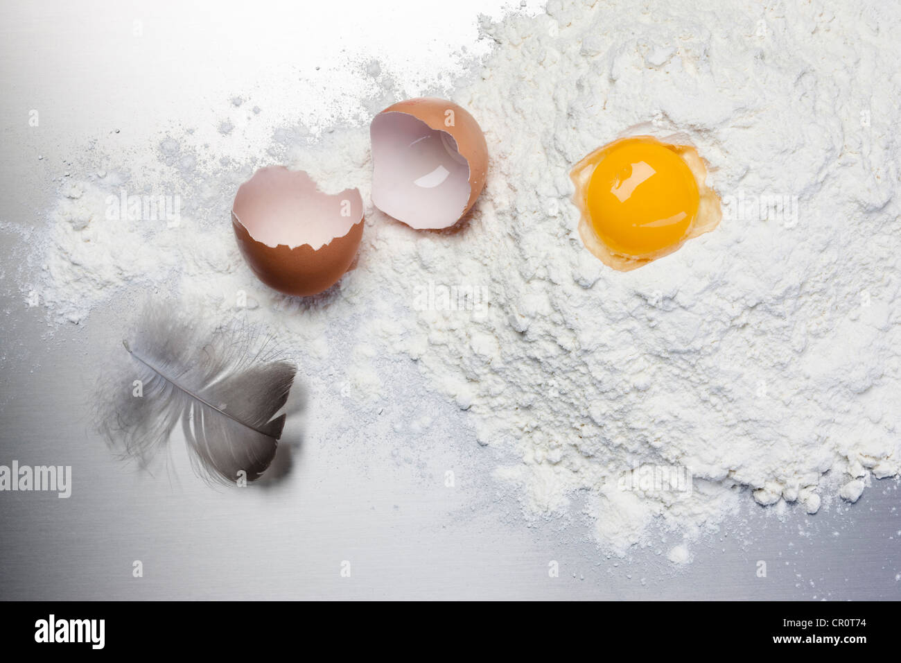 Flour and an egg on a stainless steel work surface Stock Photo - Alamy