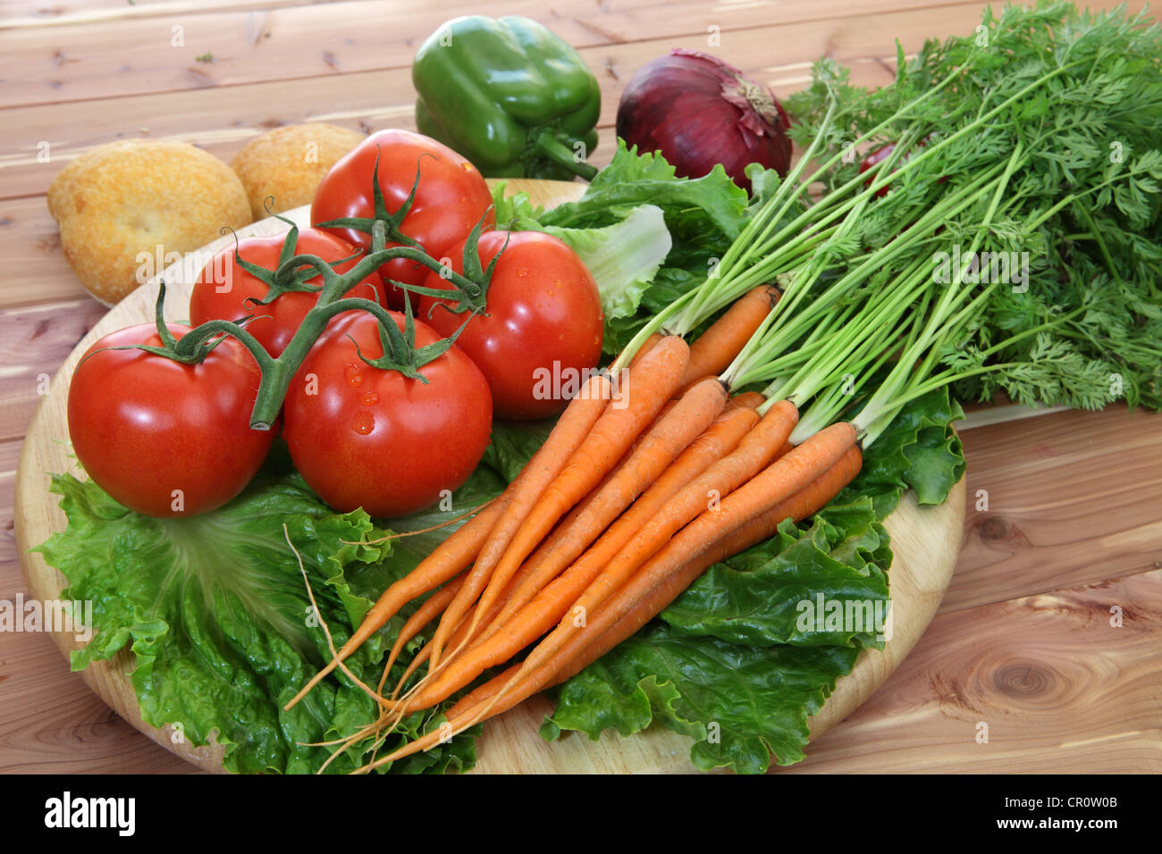 Organic vegetables in rustic setting including tomatoes on the vine ...