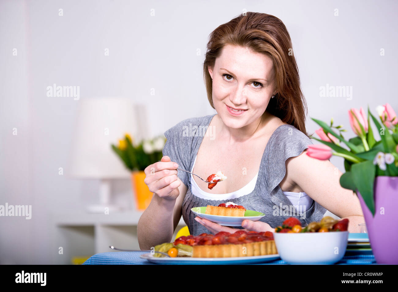 A young woman eating fresh strawberry cake Stock Photo - Alamy