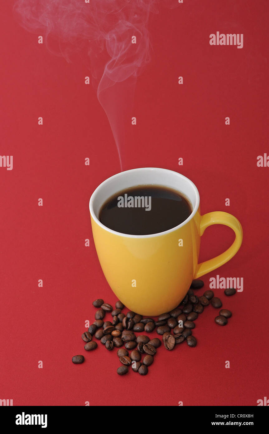 Steaming coffee cup with coffee beans Stock Photo - Alamy