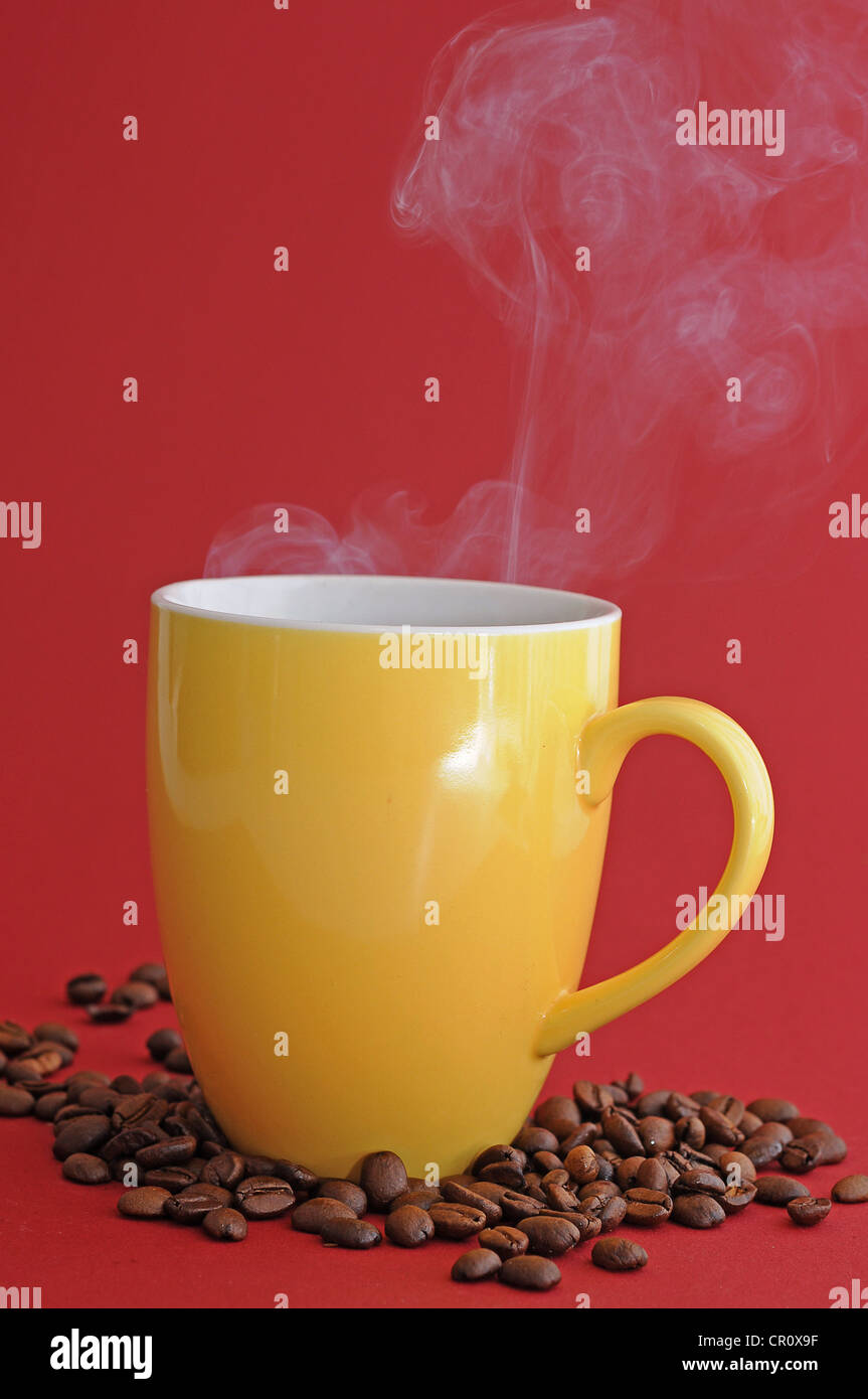 Steaming coffee cup with coffee beans Stock Photo - Alamy