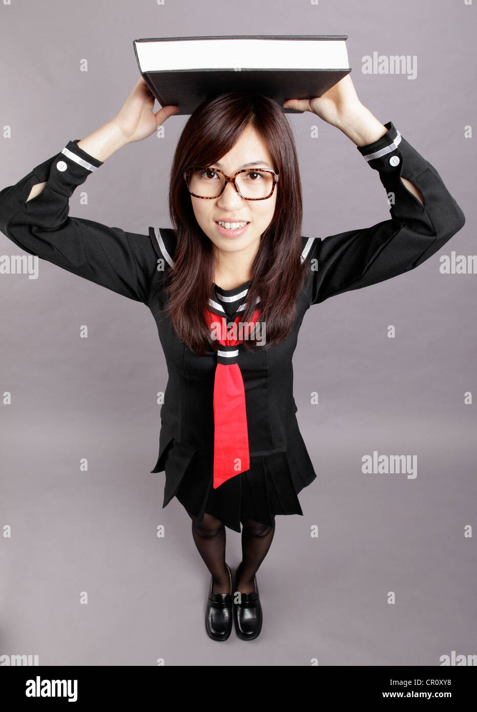 School girl lifts a heavy book Stock Photo - Alamy