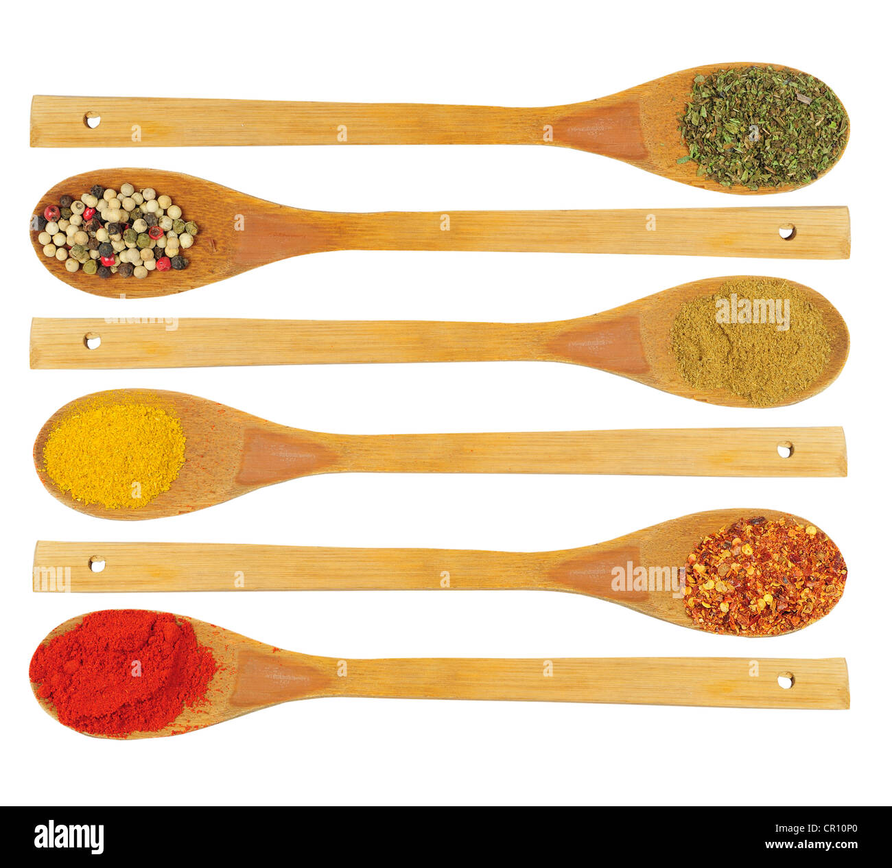 Various colorful dried spices in wooden spoons - parsley, pepper ...