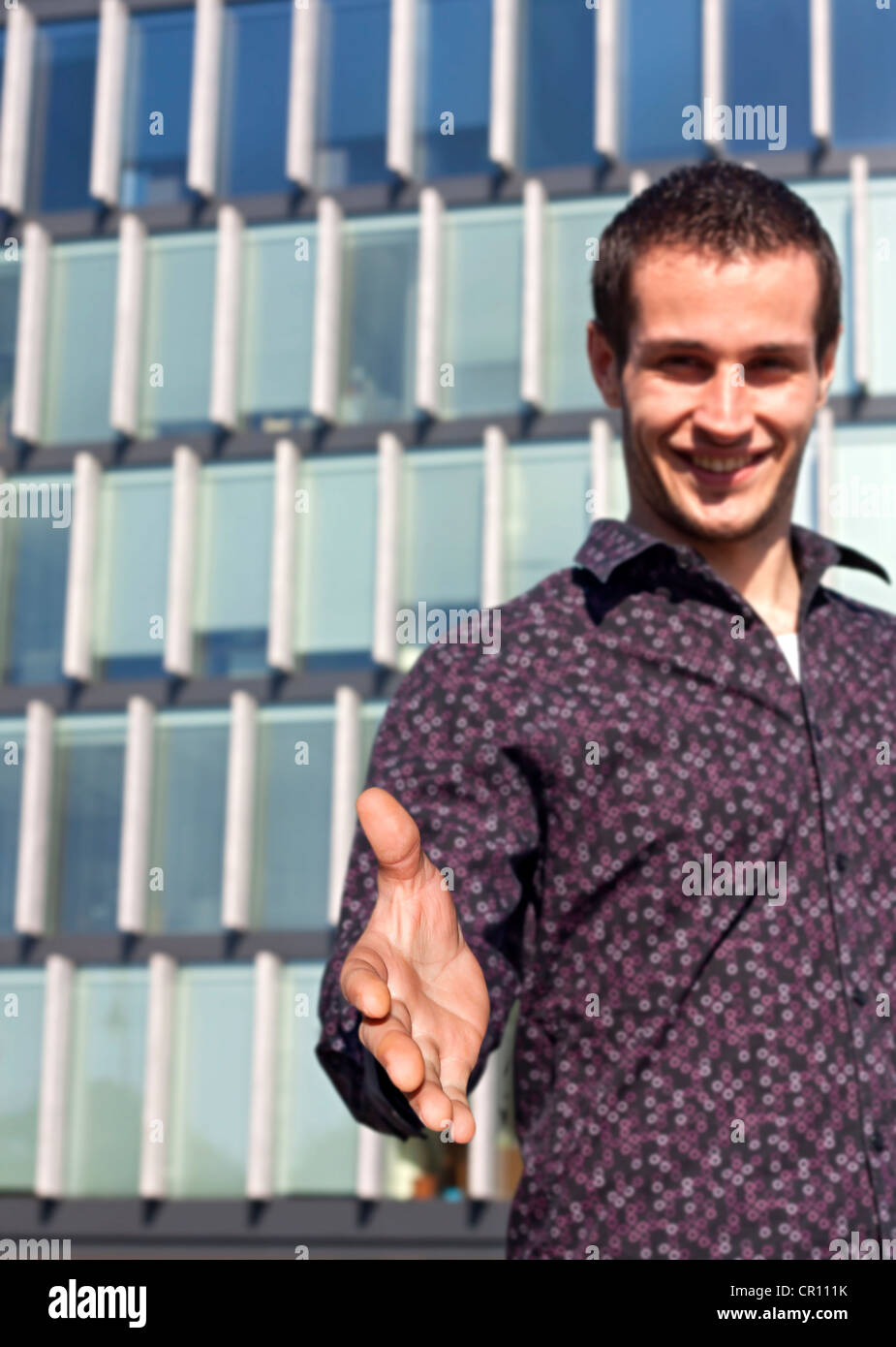 young student gives handshake against school buildings invitation to ...