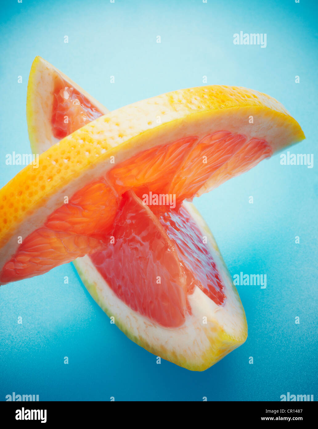 Grapefruit pieces in blue background Stock Photo - Alamy