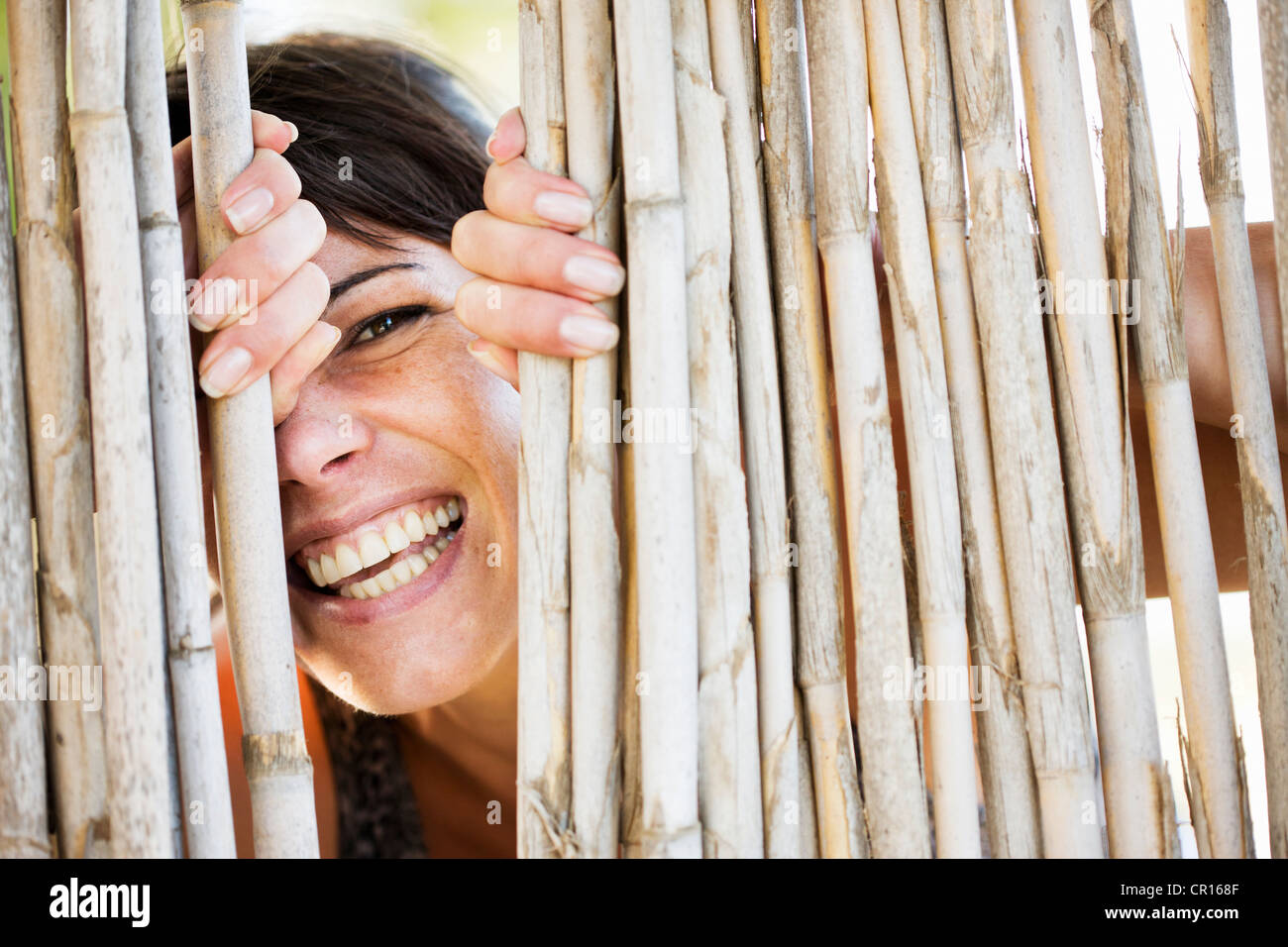 Smiling woman behind fence hi-res stock photography and images - Alamy