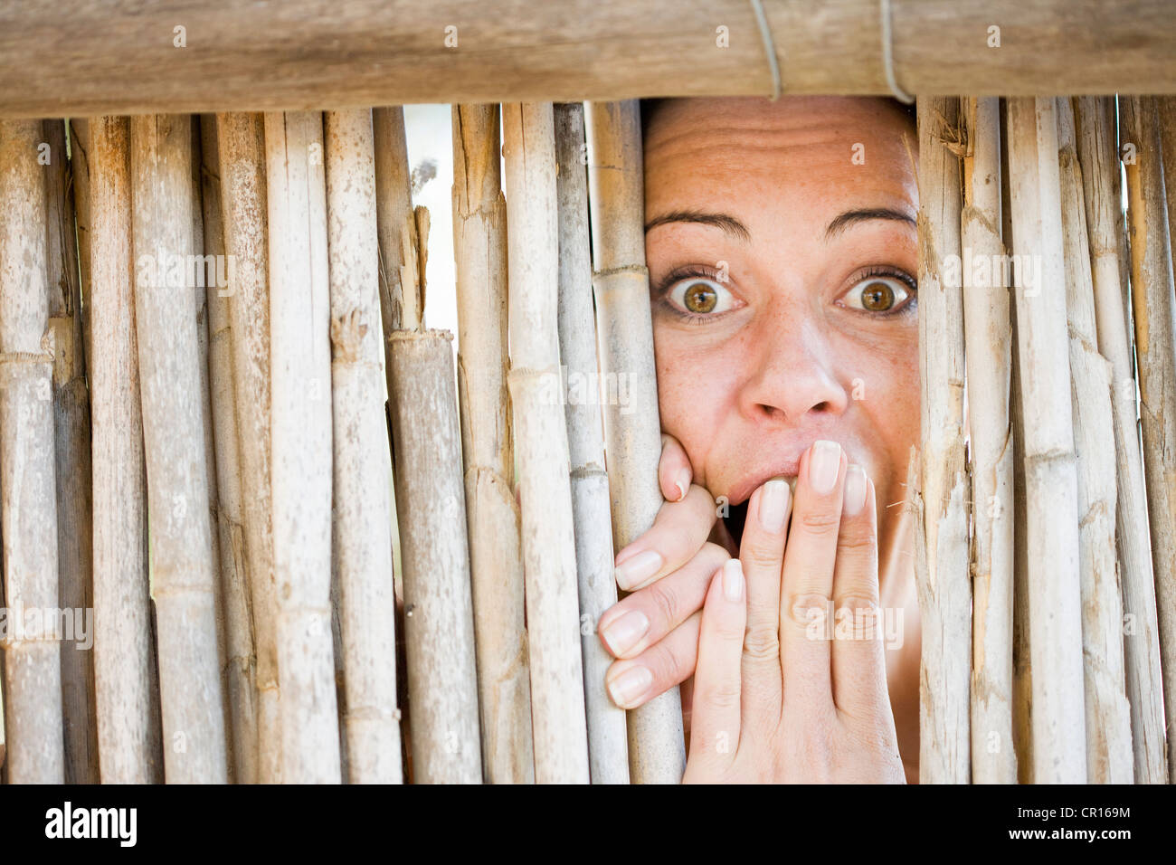 Close up of woman gasping behind fence Stock Photo - Alamy