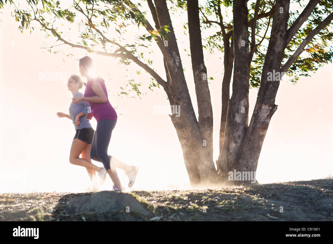 Women running together on dirt path Stock Photo - Alamy