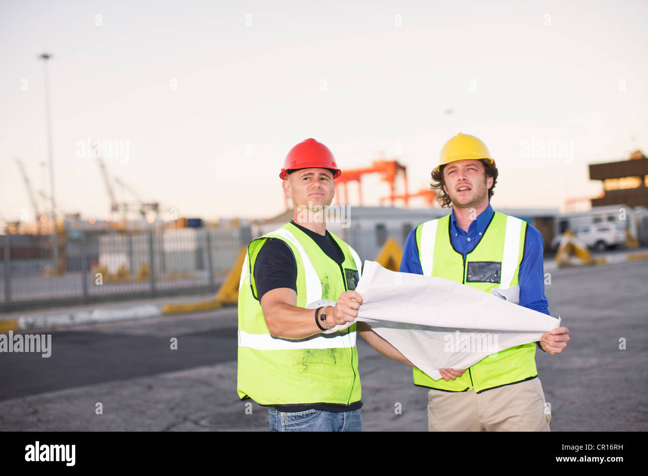Construction workers reading blueprint Stock Photo - Alamy