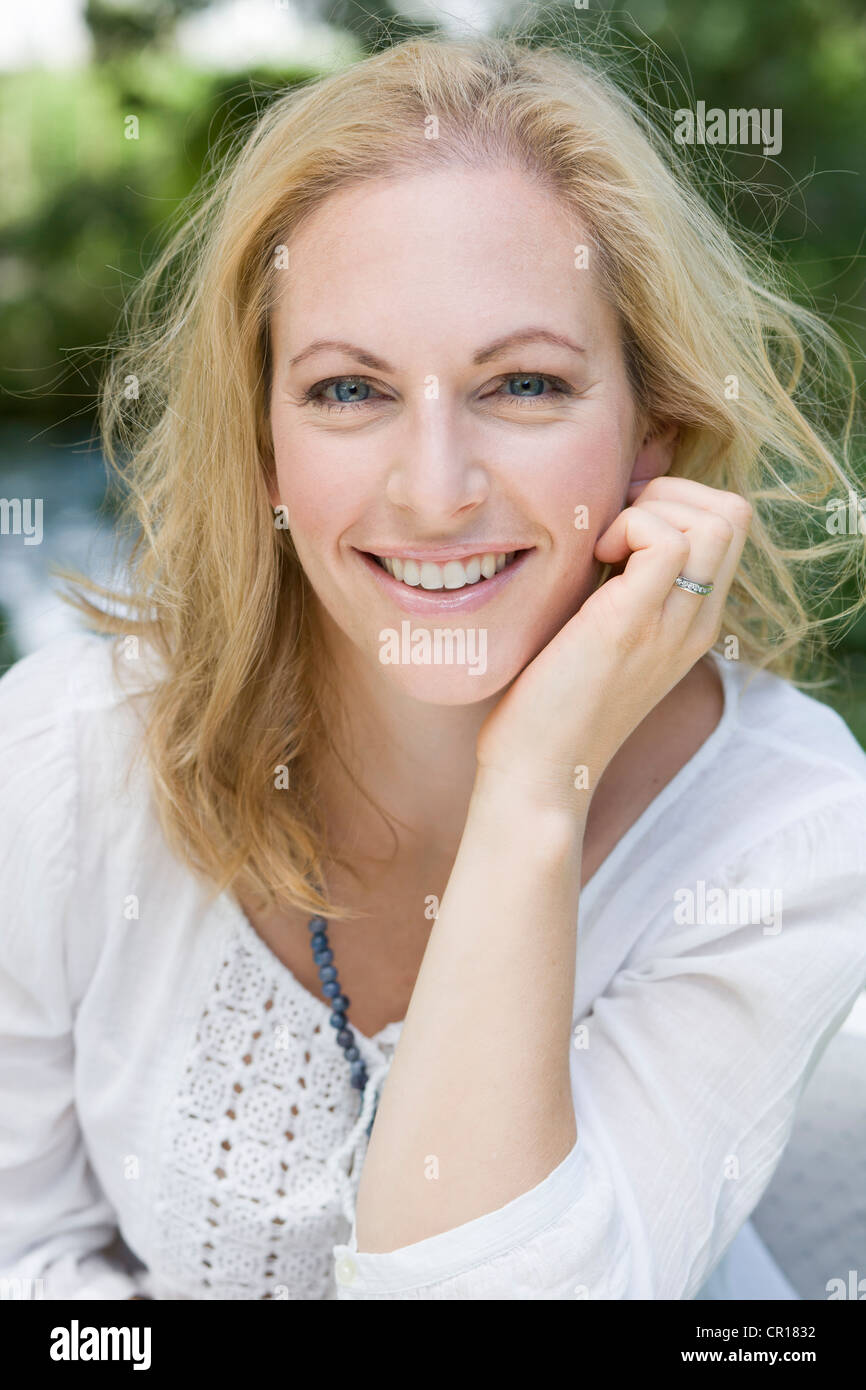 Smiling woman sitting outdoors Stock Photo - Alamy