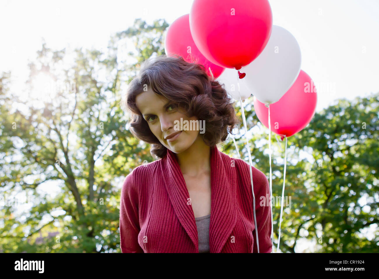 Woman carrying balloons outdoors Stock Photo - Alamy