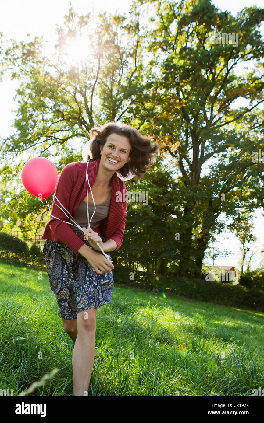 Smiling woman carrying balloons Stock Photo - Alamy