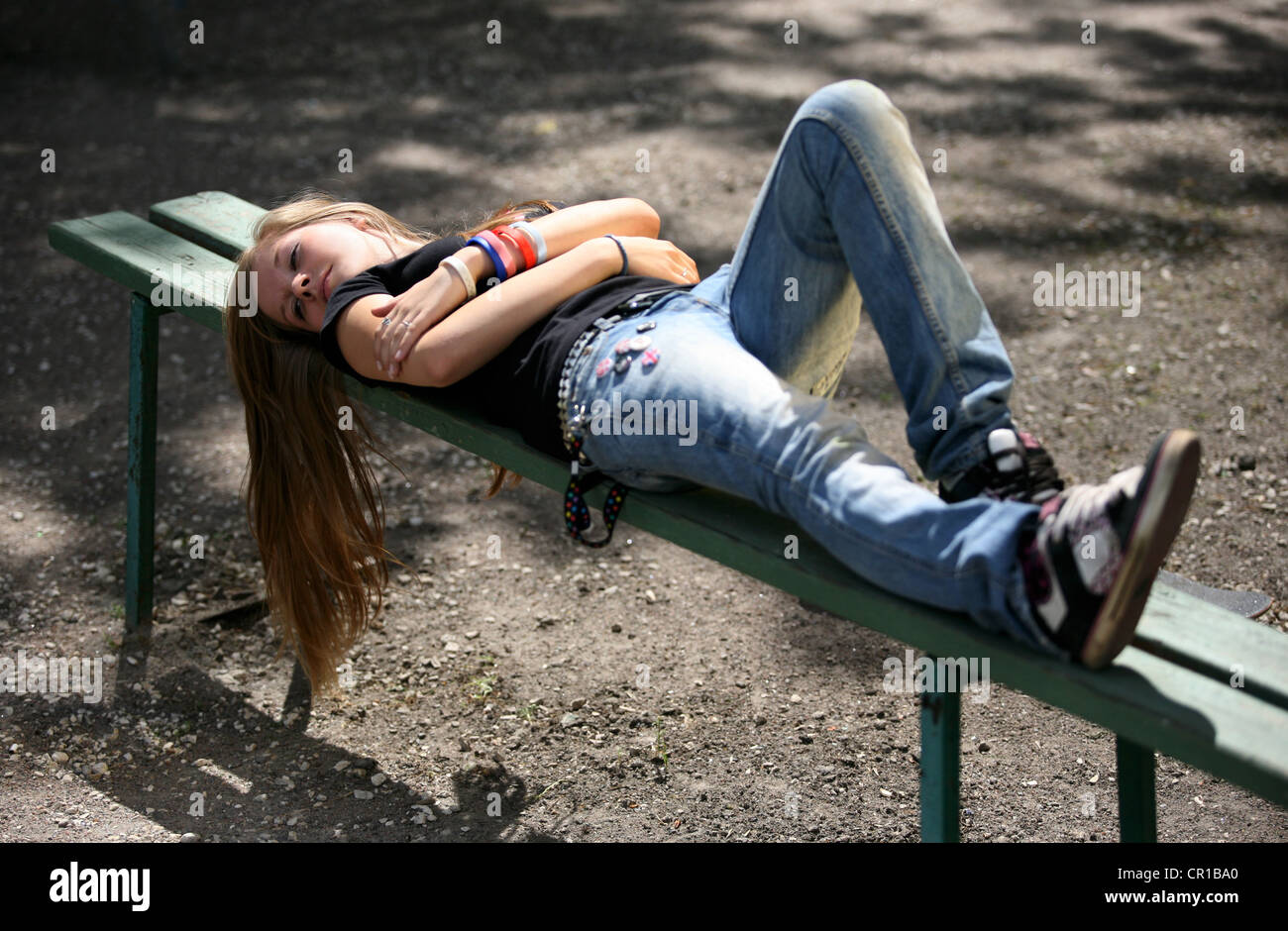 The young girl lays on a bench Stock Photo - Alamy