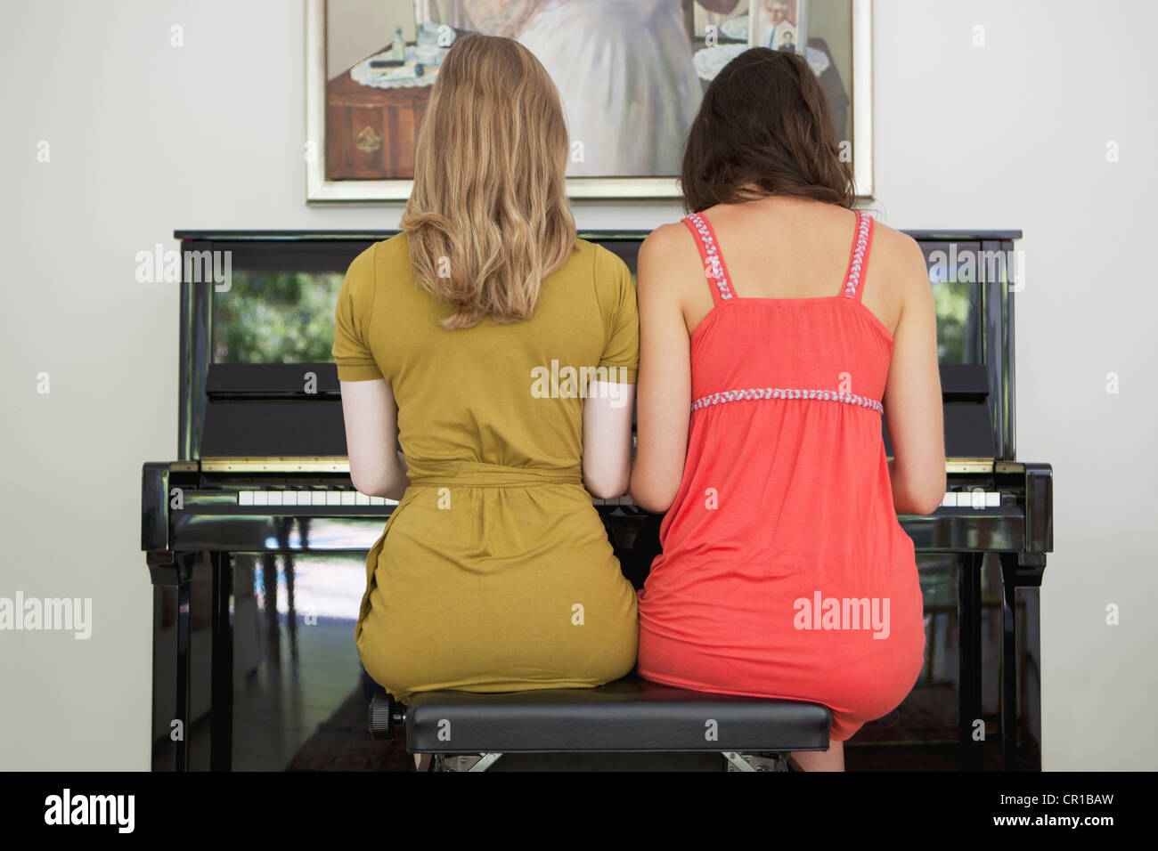 Teenage girls playing piano together Stock Photo - Alamy