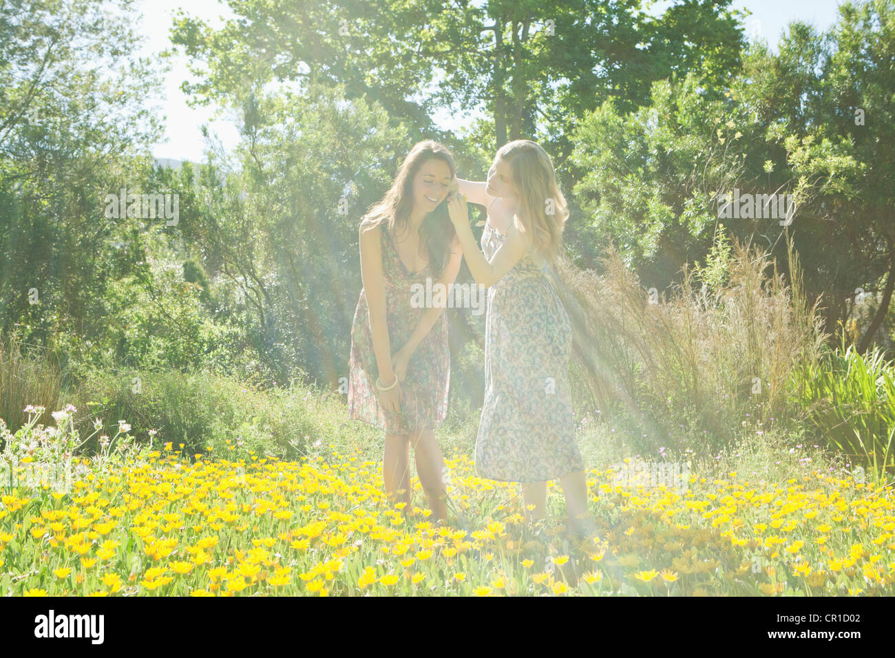 Teenage girls in field of flowers Stock Photo - Alamy